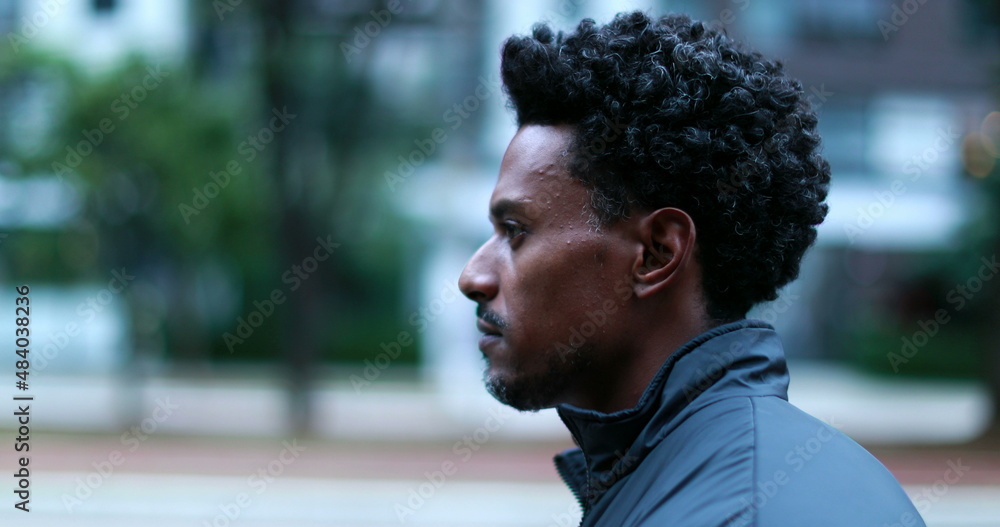 Man of african descent walking in city. Mixed race person walks in ...