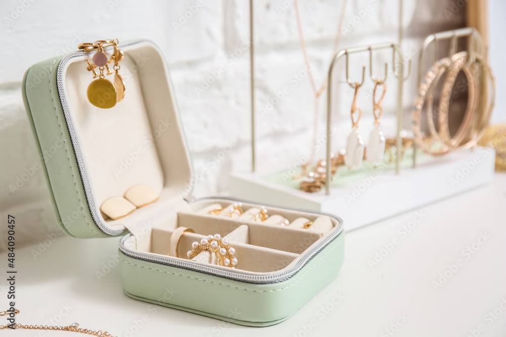 Opened jewelry box on table near white brick wall Stock Photo | Adobe Stock