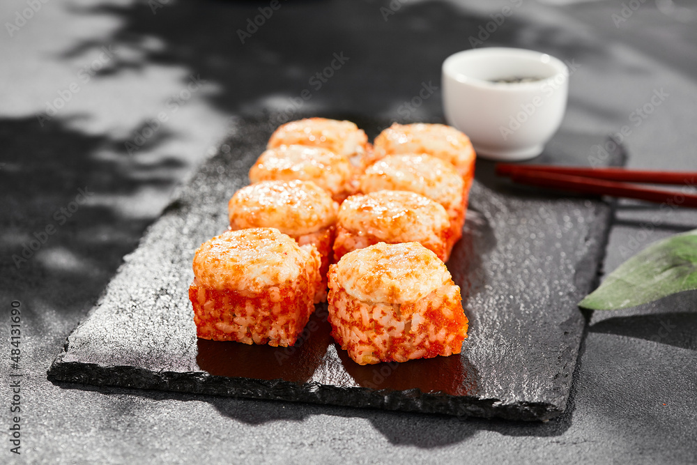 Foto de Baked Maki sushi on dark slate. Hot california maki with tobiko ...