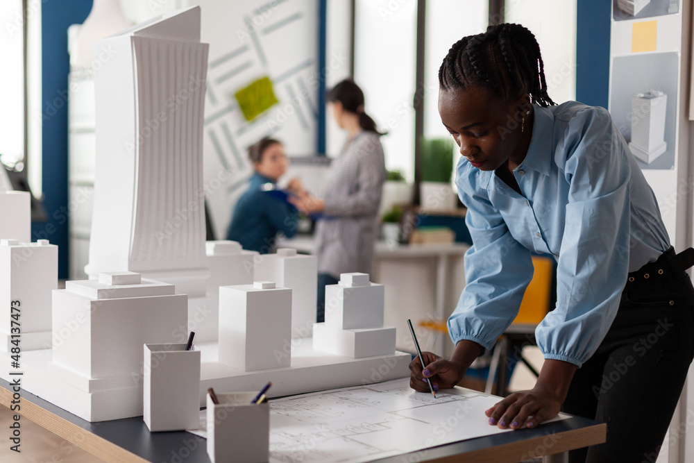 Residential architect drawing blueprints at desk in architectural ...