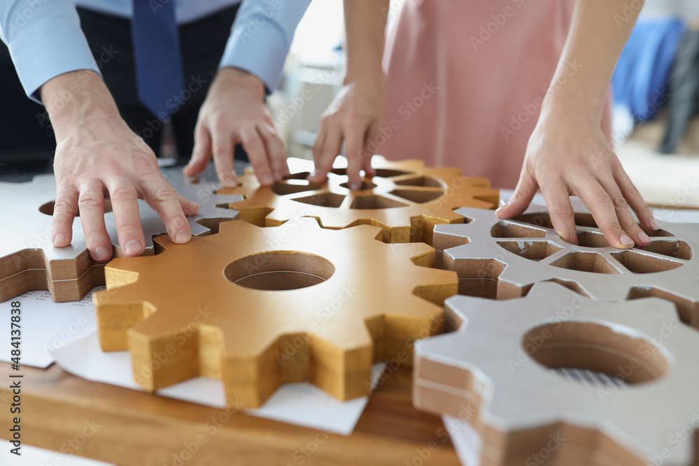 Businesspeople put wooden gears on workplace together, work in team ...