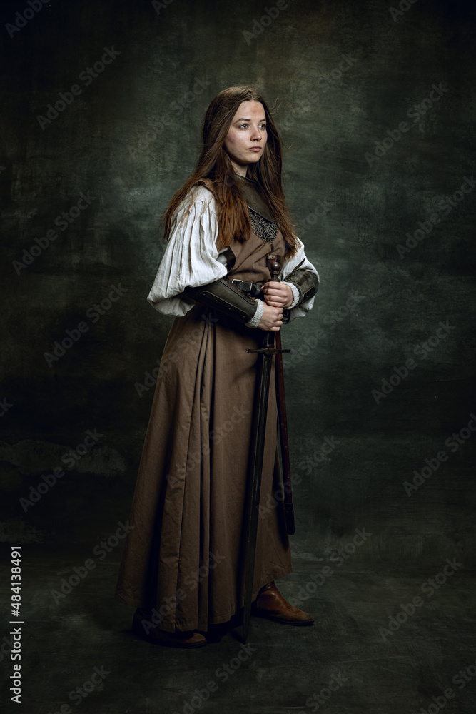 Full-length portrait of seriuos beautiful woman in image of medieval ...