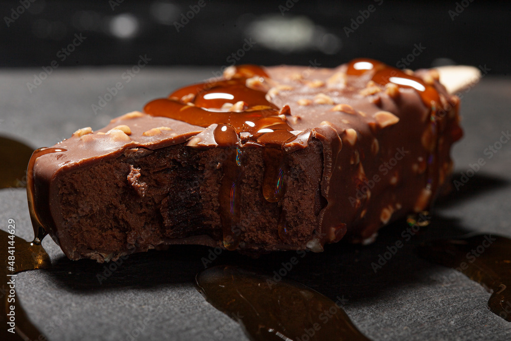 Bitten chocolate ice cream with almonds. Close-up. Against the ...