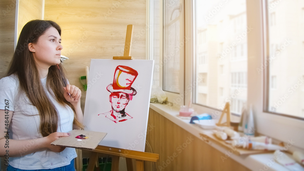 Pensive girl stands near picture and thinks what to draw. Drawing ...