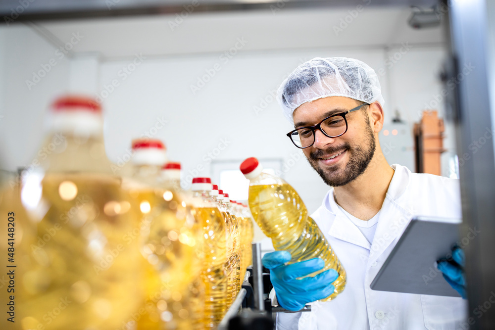 Food factory worker or technologist in white lab coat and hairnet ...