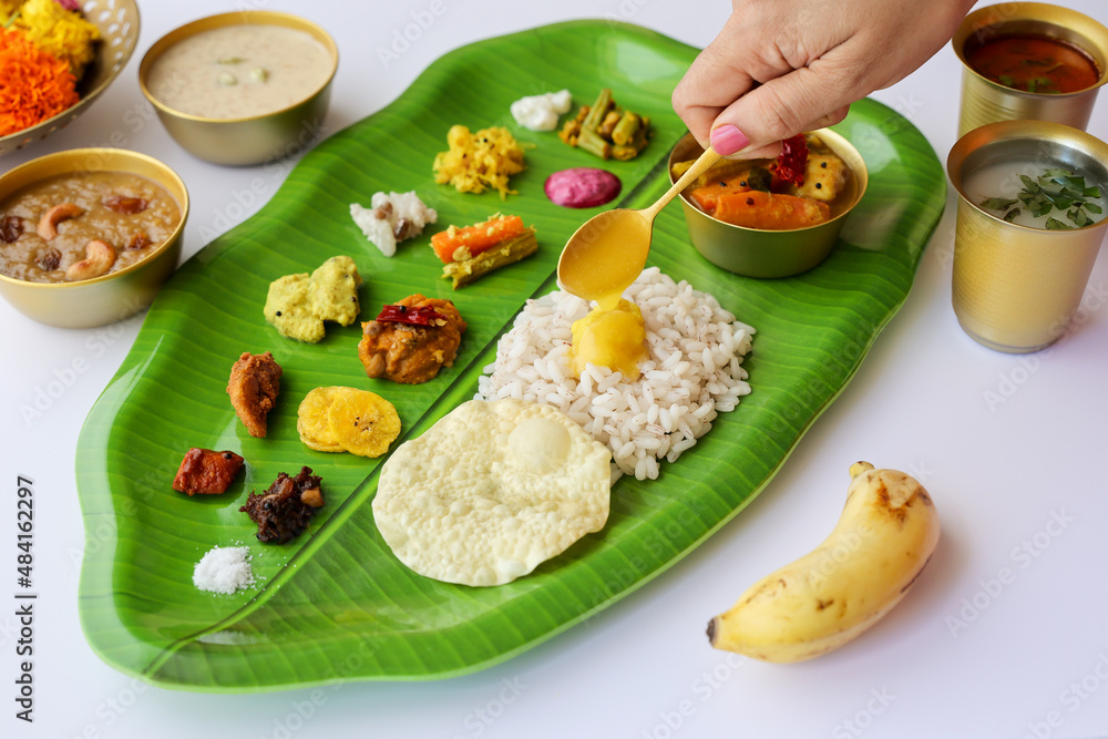 Plakat Woman hand serving parippu dal curry ghee traditional Onam ...