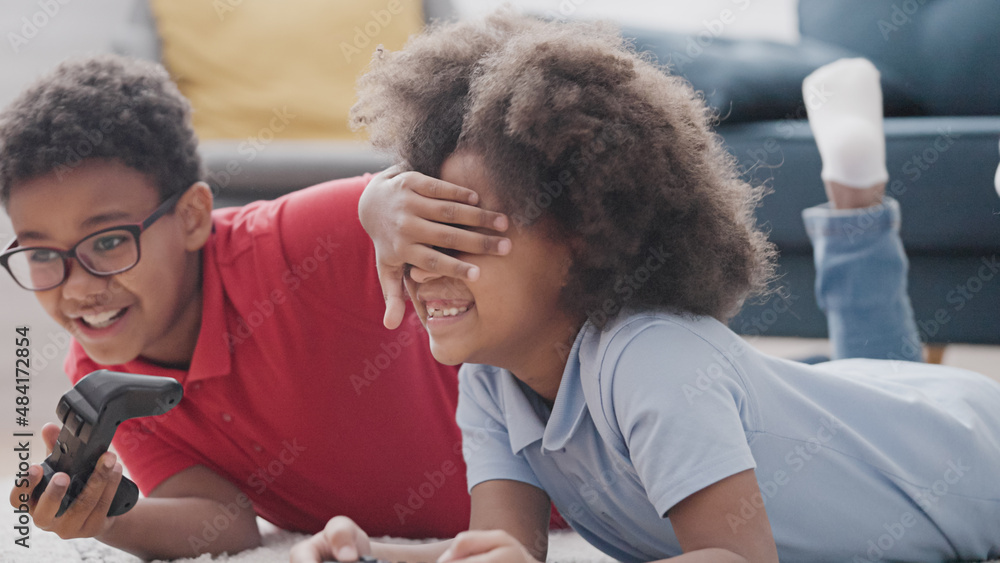 Excited african american children having fun playing video game with ...