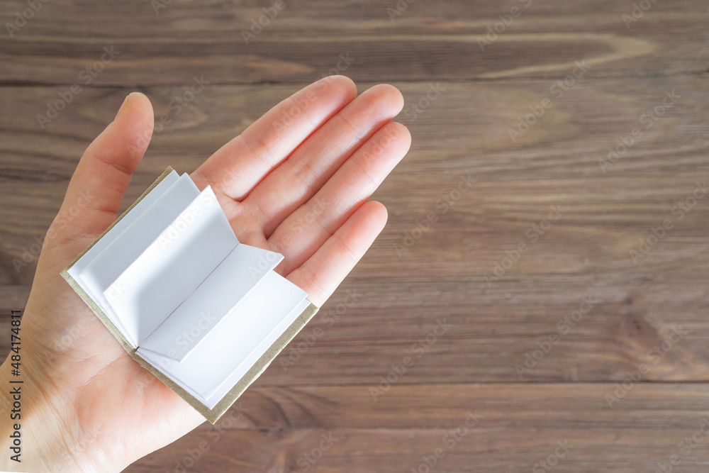 Small open book on the palm of the hand Stock Photo | Adobe Stock