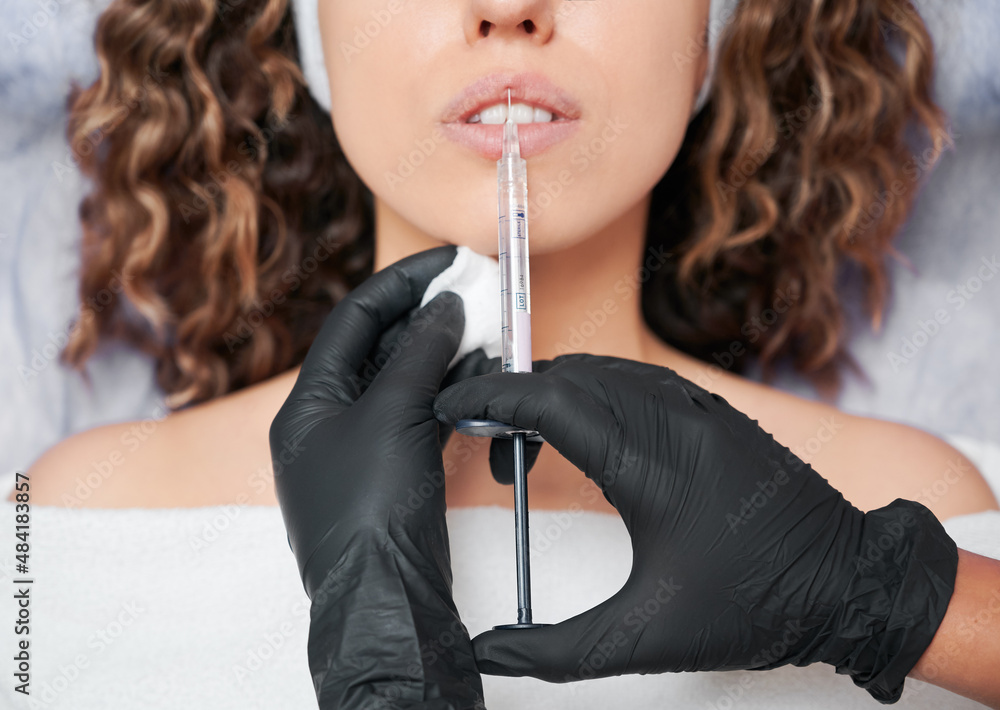Cropped view of sensual female face during lip augmentation procedure ...