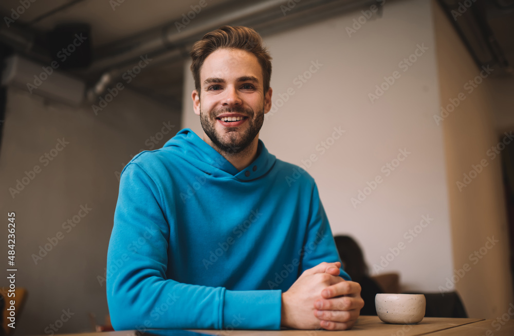 Half length portrait of cheerful male customer smiling at camera during ...