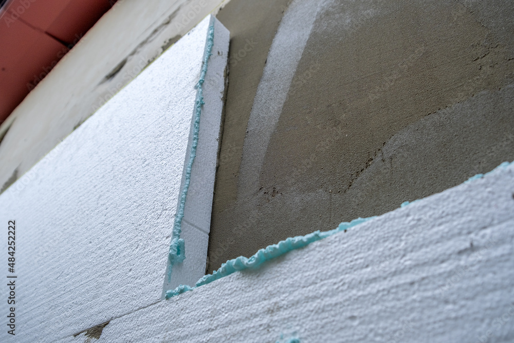 Installation of styrofoam insulation sheets on house facade wall for ...