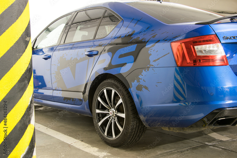Blue sports car with black wheels parked in an underground garage. It ...