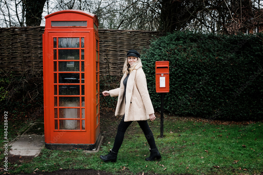 woman walking between an English telephone box and post box Stock Photo ...