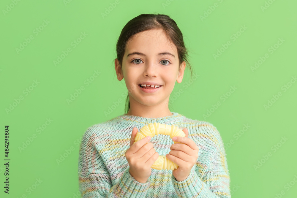 Little girl with yellow Pop Tube on green background Stock Photo ...
