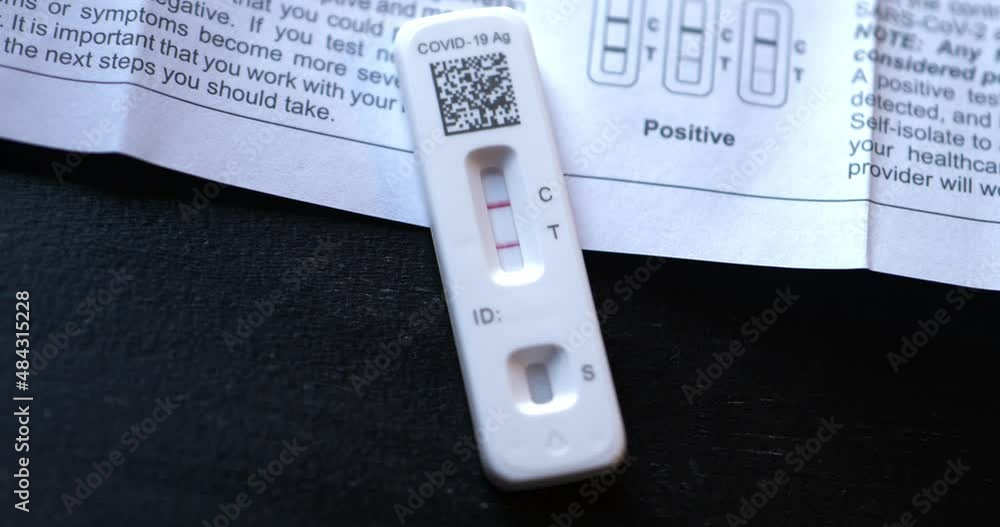 Covid 19 positive at home antigen test kit on black table with ...