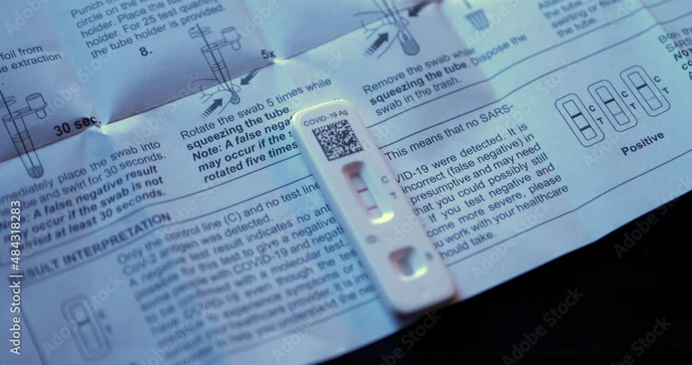 Covid 19 positive at home antigen test kit sitting on instruction book ...
