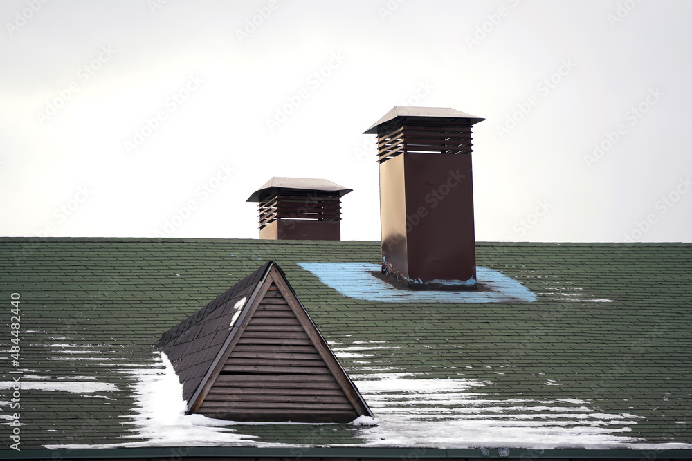 The roof of the building is covered with green tiles with ventilation ...