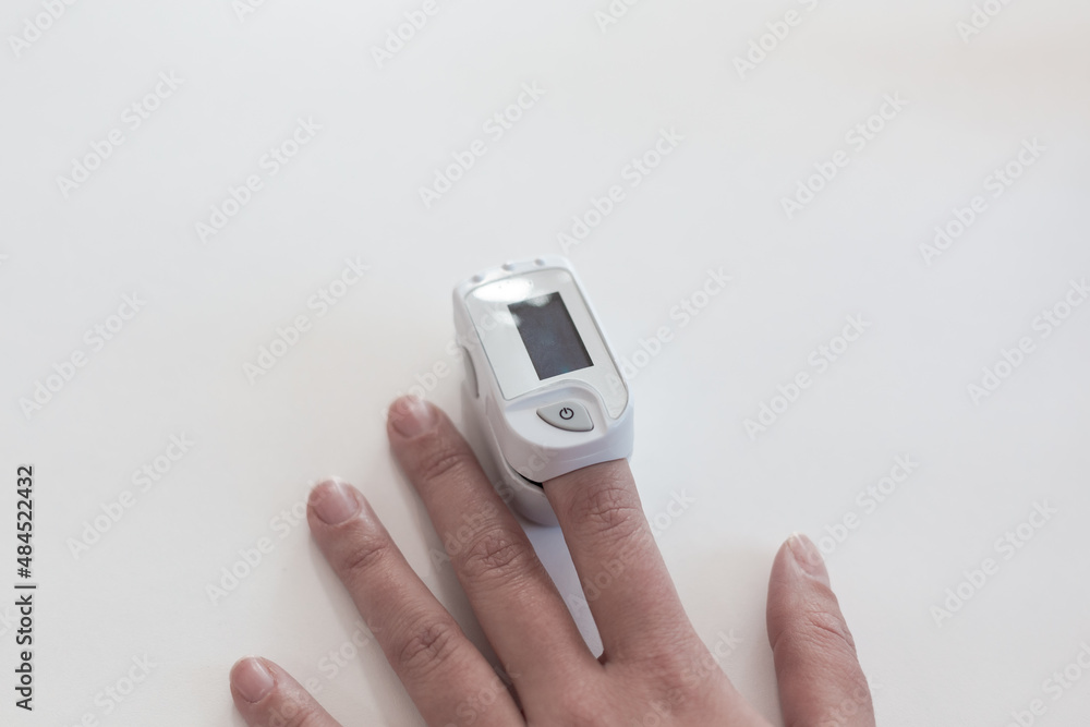 Pulse oximeter on a woman's finger. blood oxygen saturation. The ...