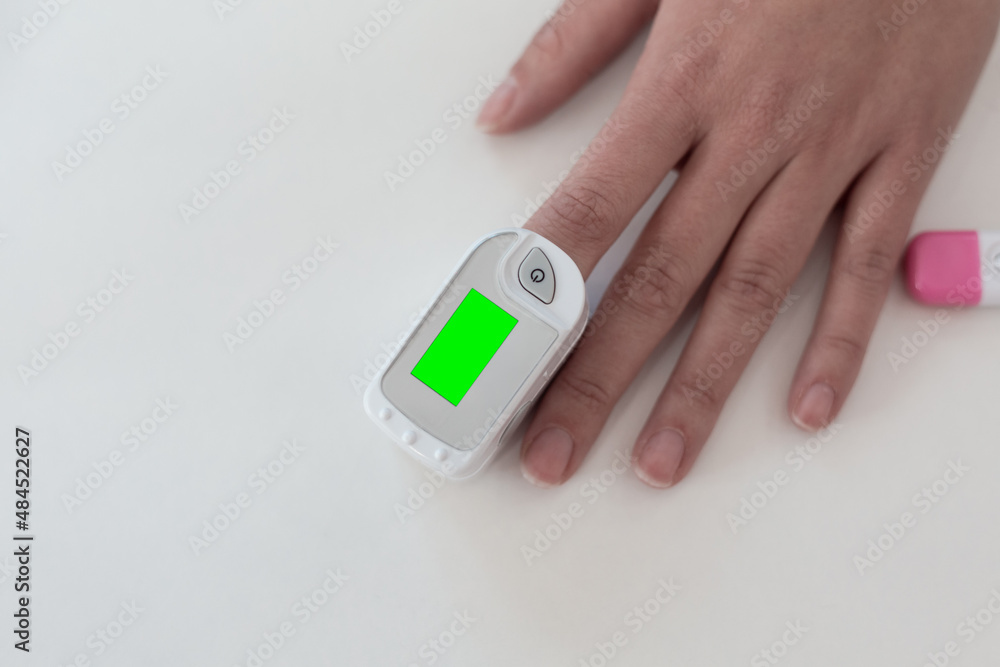 Pulse oximeter on a woman's finger. blood oxygen saturation. The ...