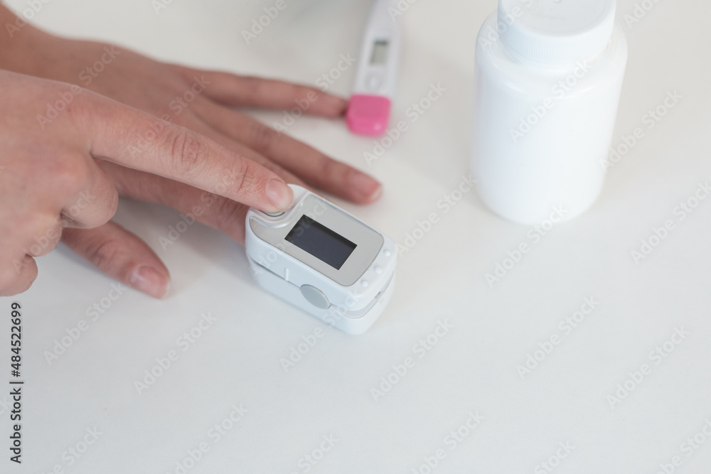 Pulse oximeter on a woman's finger. blood oxygen saturation. The ...