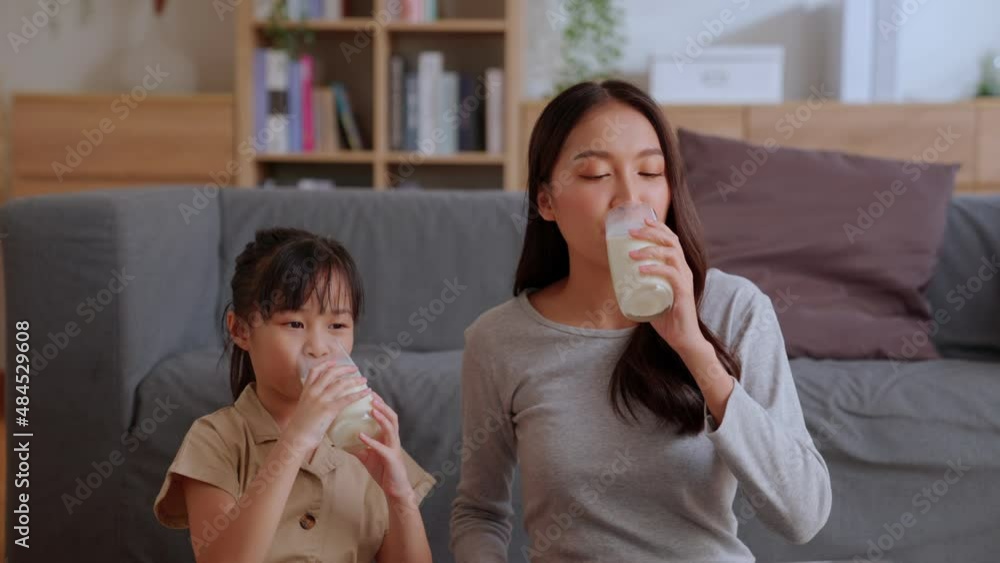 Portrait of Asian happy family mom and child clinking a glass of milk ...
