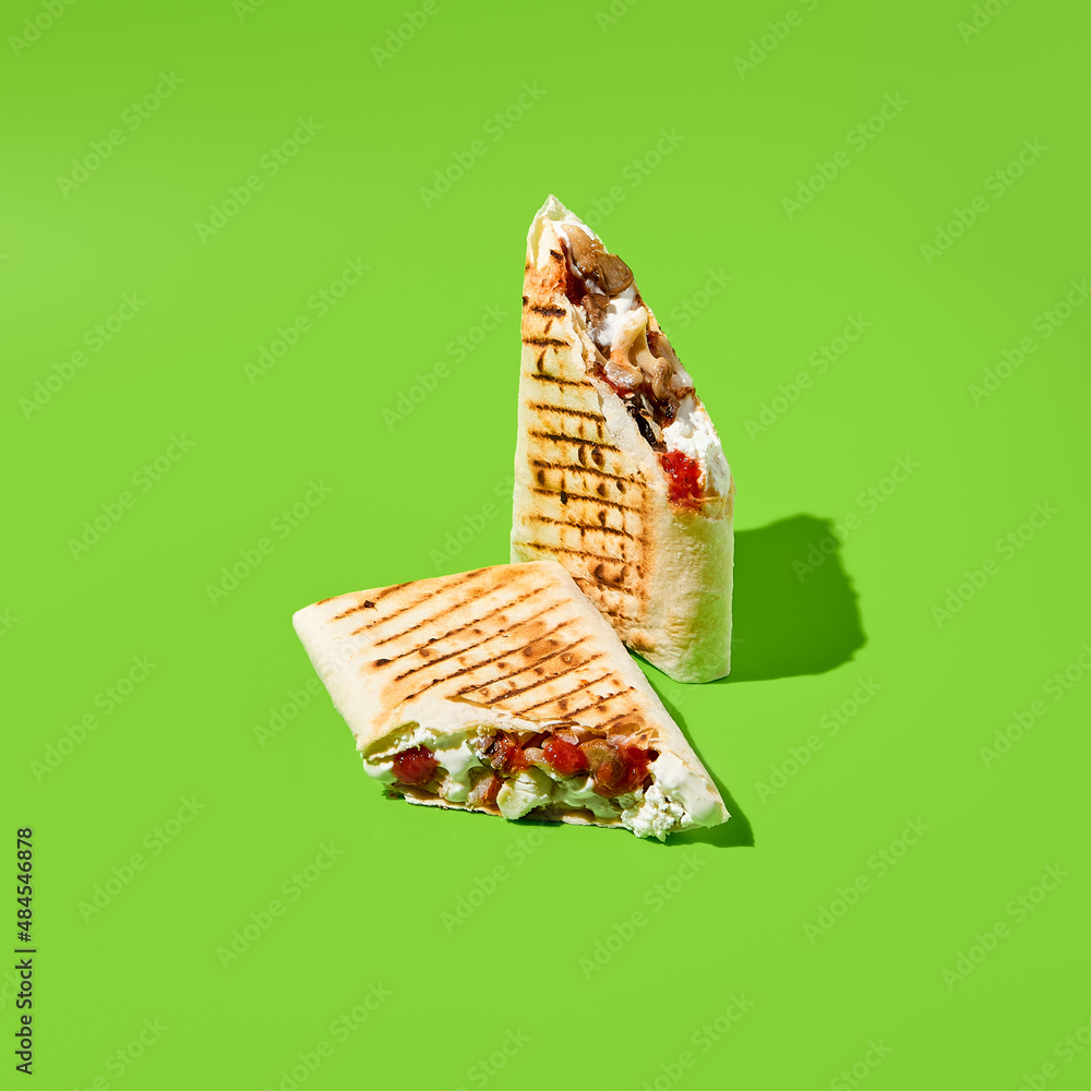 Shawarma with vegetables and meat on green background. Contemporary ...
