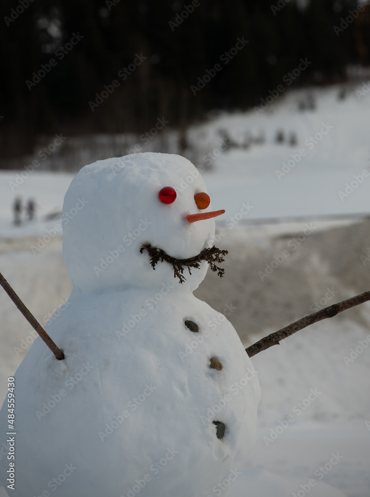large happy snowman at ski resort with rock buttons carrot for nose red ...