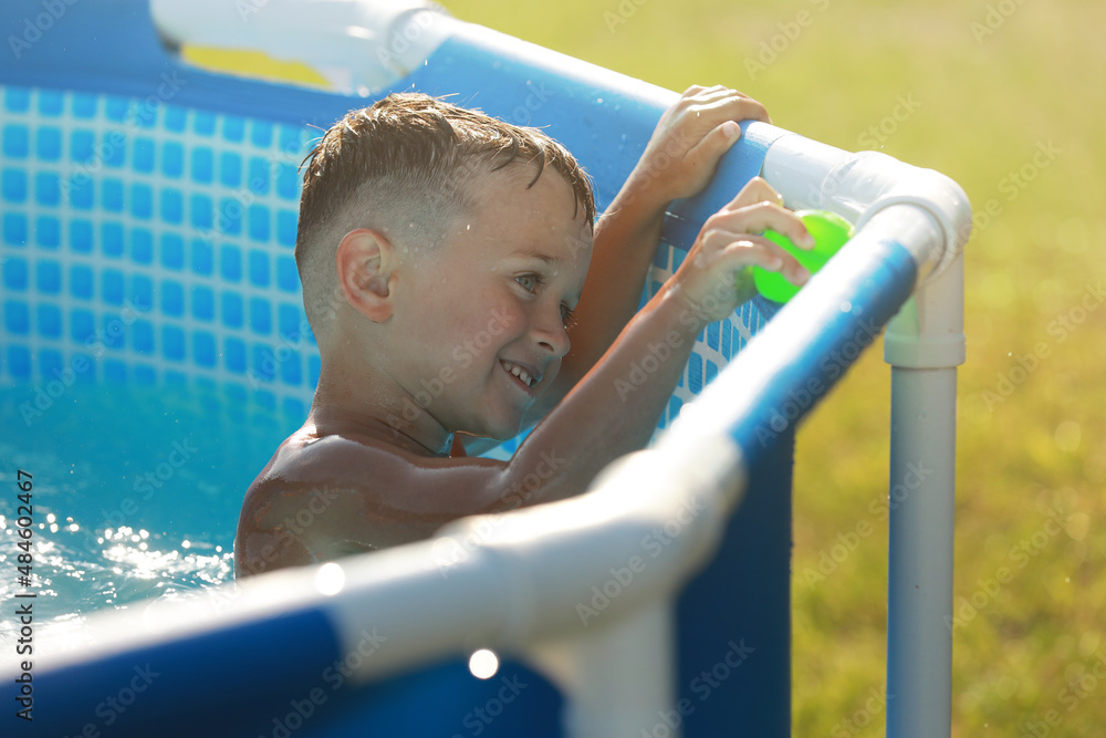 Portrait smiling boy is playing in swimming pool. Summer vacation or ...