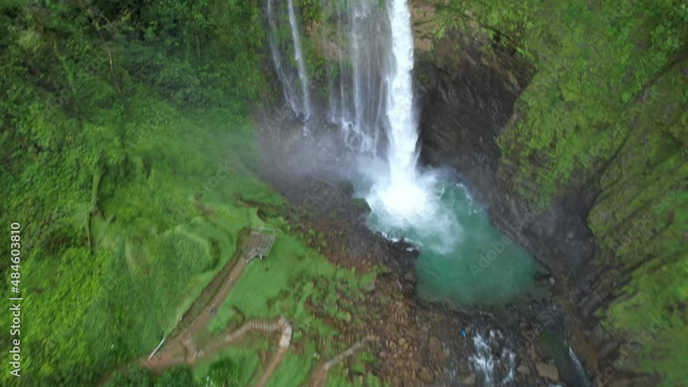 Aerial dolly out of Eco Chontales waterfall falling down rocky natural ...