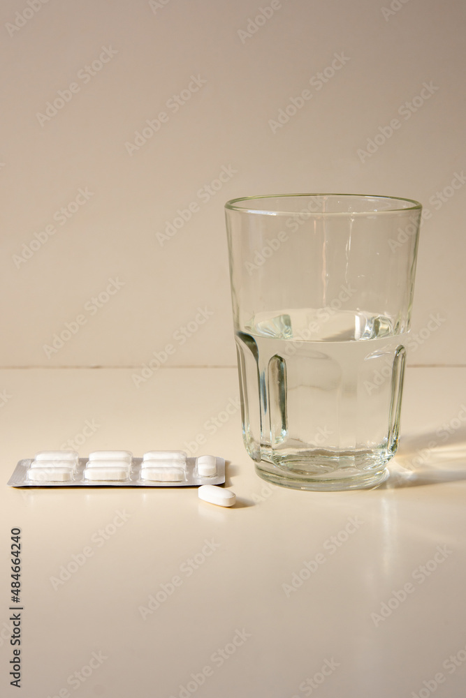 Pasillas des inflamatorias analgésico y antifebril con un vaso de agua ...