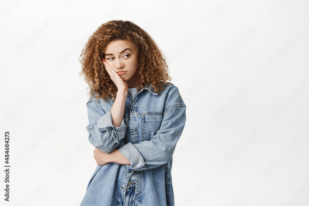 Bored young woman, facepalm and look aside with annoyed, unamused face ...