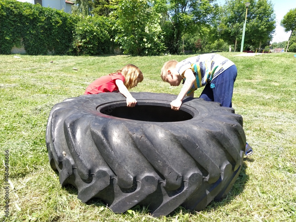 Children play and pick up the tire. Car parts and accessories in a kid ...