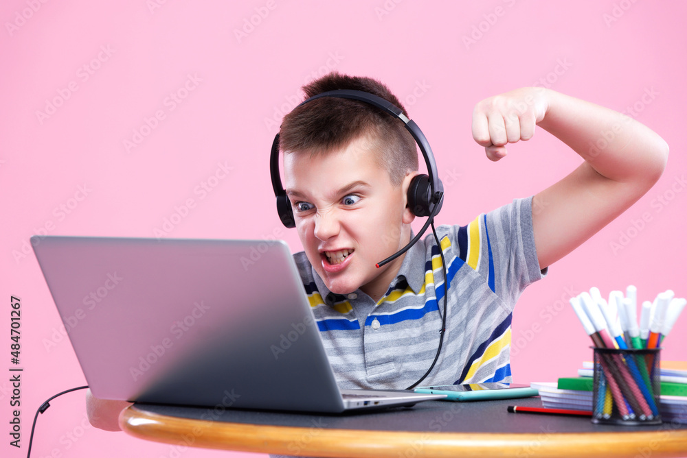 Furious teenage boy about to hit the laptop screen, angry with the ...