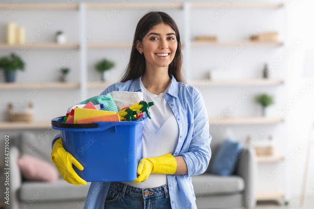 Young housewife holding bucket with cleaning supplies tools Stock Photo ...