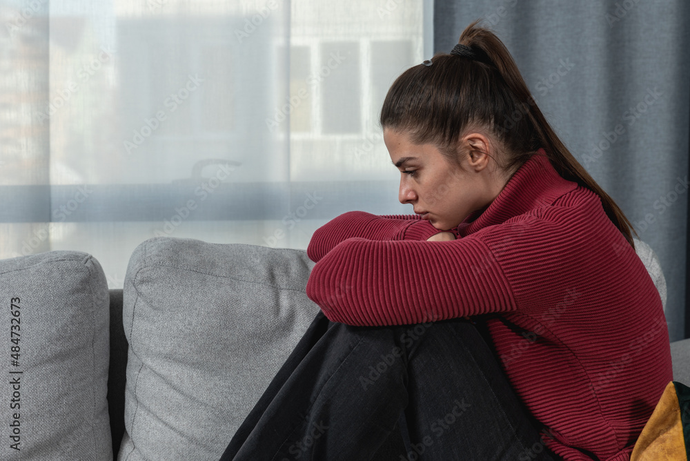 Young sad woman with broken heart sitting alone at home suffering from ...