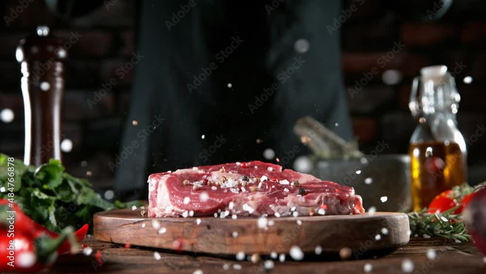 Super slow motion of chef throwing spices on beef steak. Filmed on high ...