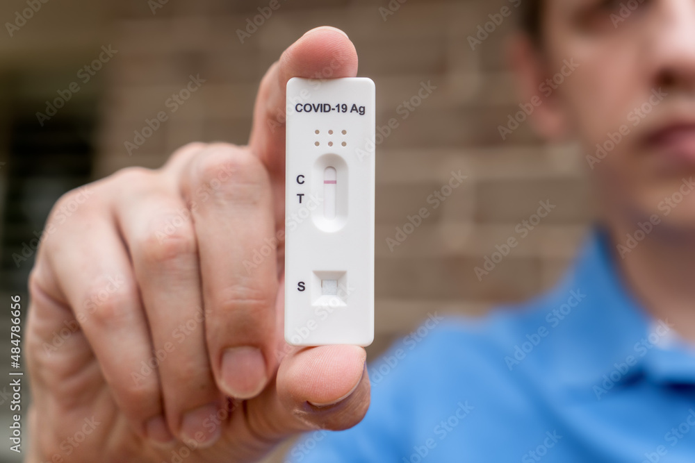 Man holding Covid-19 rapid antigen test cassette with negative result ...