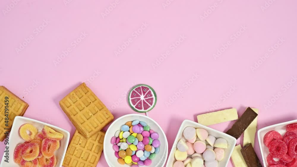 Sweet desserts, gummy and chocolate candies and lollypops appear on ...