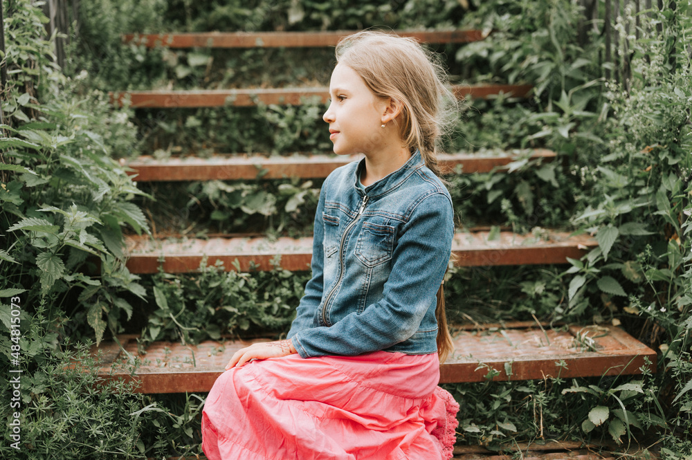 happy smiling candid eight year old kid girl sits on staircase ...