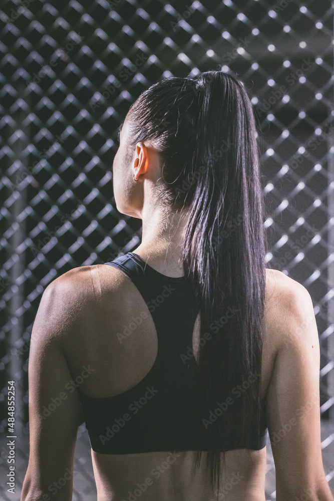 Back view of the sportswoman against the background of a tatami mesh in ...