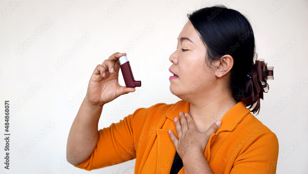 Asian female patient is using asthma inhaler. Concept : Health care at ...