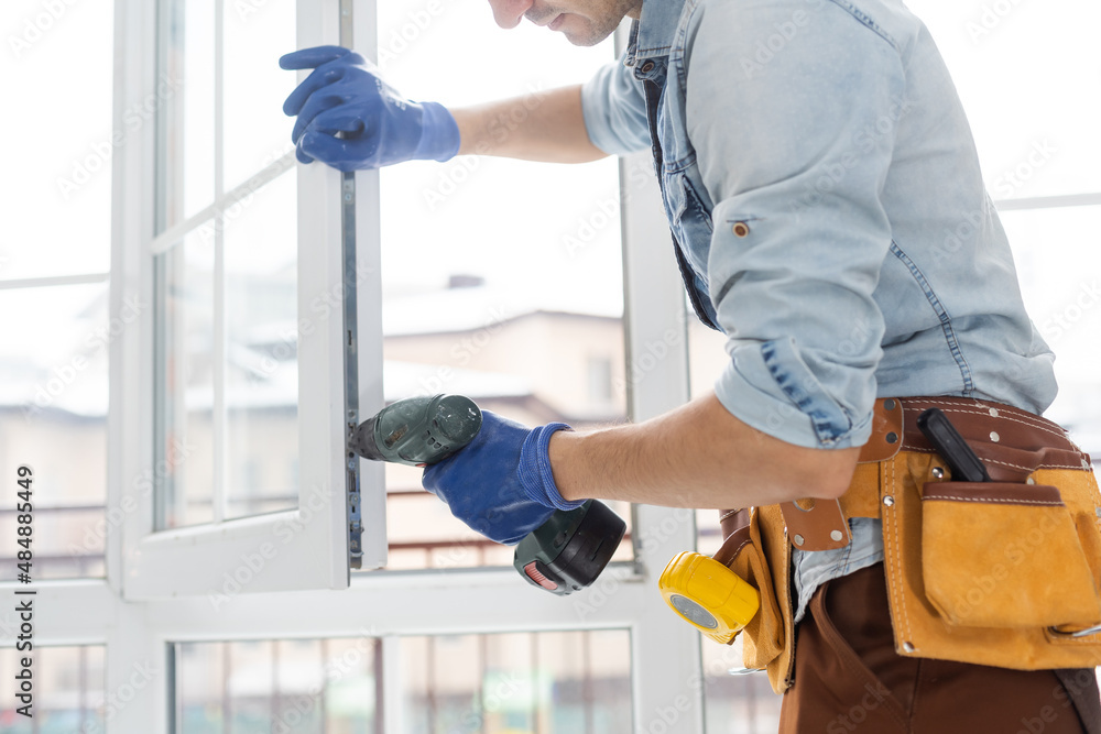 Construction worker installing window in house. Handyman fixing the ...