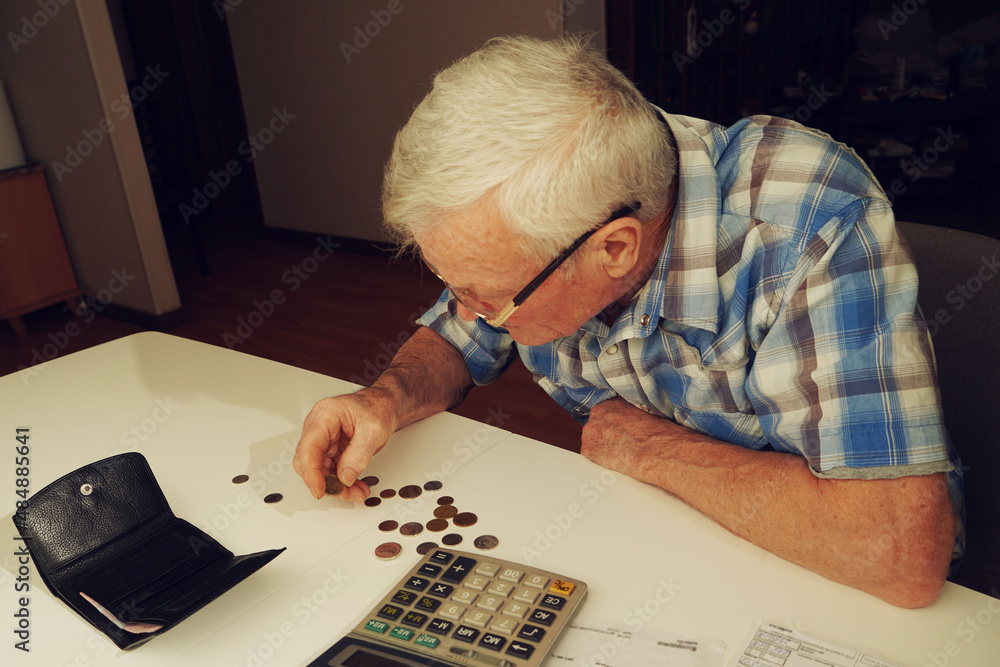 Upset Senior man sitting at the table and calculating finances. Old man ...