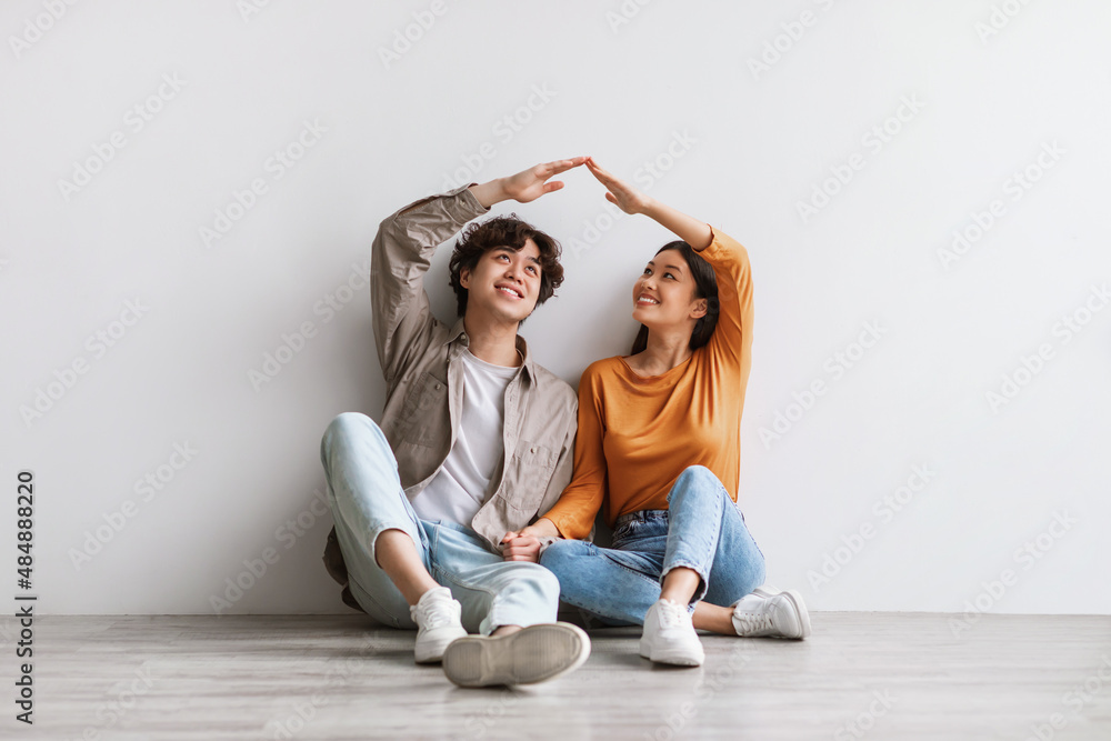 Foto De Positive Millennial Asian Couple Making Home Roof With Their
