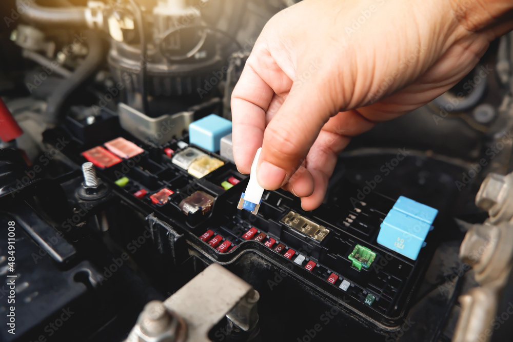 Mechanic replaces the spare fuse to the car fuse box with the fuse clip ...