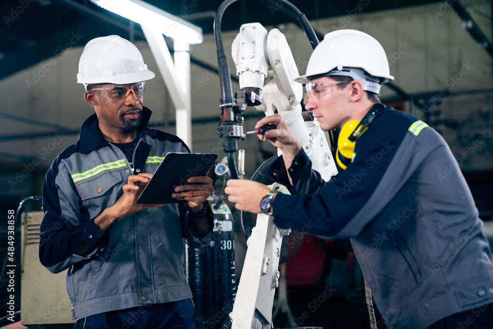 Factory workers working with adept robotic arm in a workshop . Industry ...