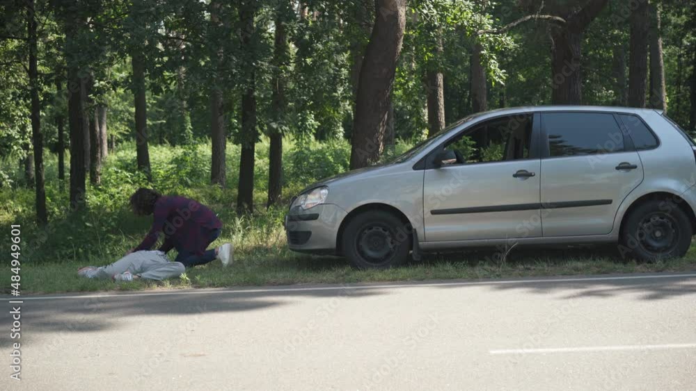 Wide shot stressed driver running to knocked down woman lying on ...