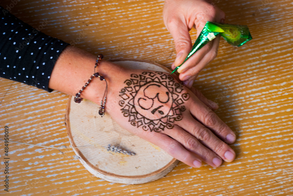 Symbol om on woman hand. Mehendi design. Stock Photo | Adobe Stock