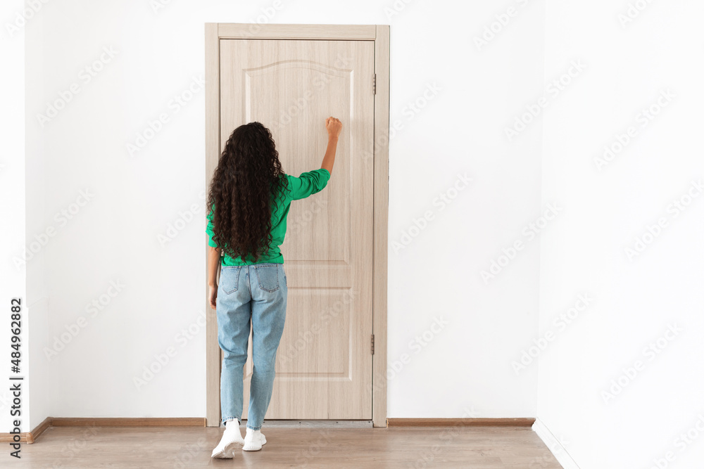 Rear back view of lady knocking on the wooden door Stock Photo | Adobe ...