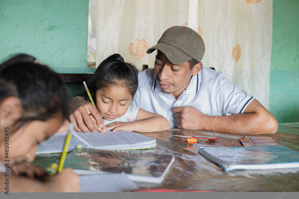 Hispanic father helping his daughters do their homework - teacher ...